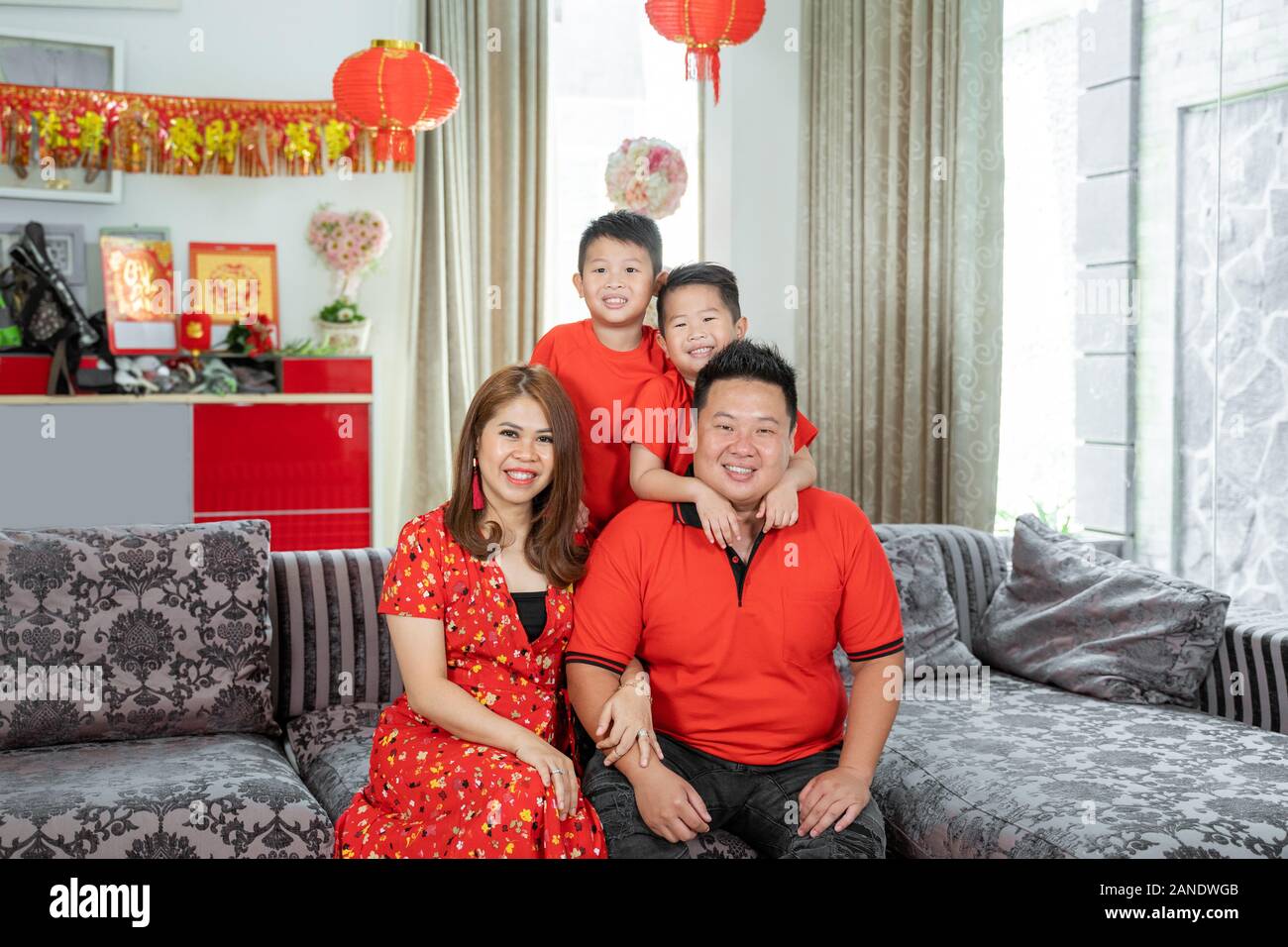 Asian family with two son holding ang pao smiling looking at camera ...