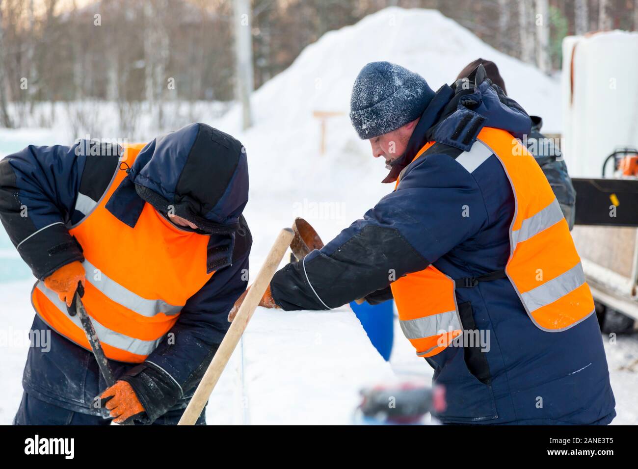 Workers in winter workwear installing ice panels Stock Photo - Alamy