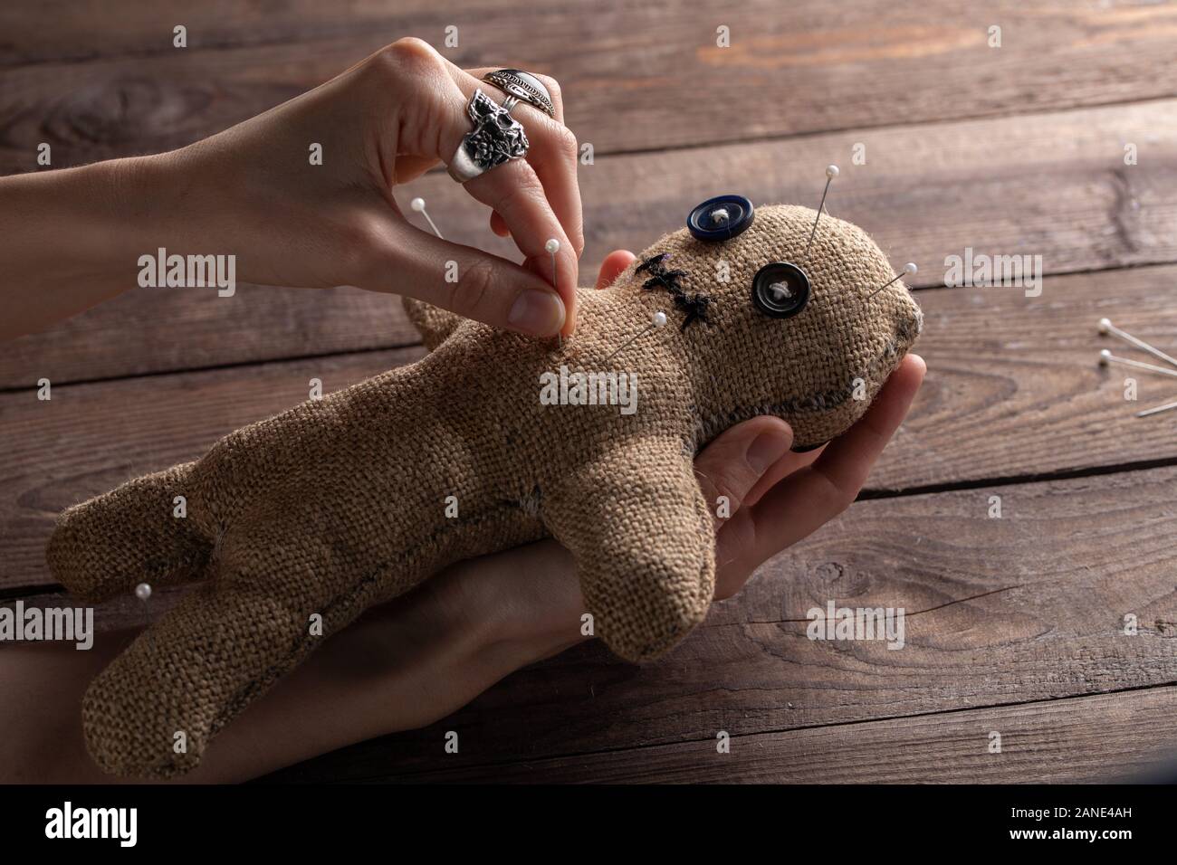 Voodoo doll on a wooden background with dramatic lighting. The concept ...