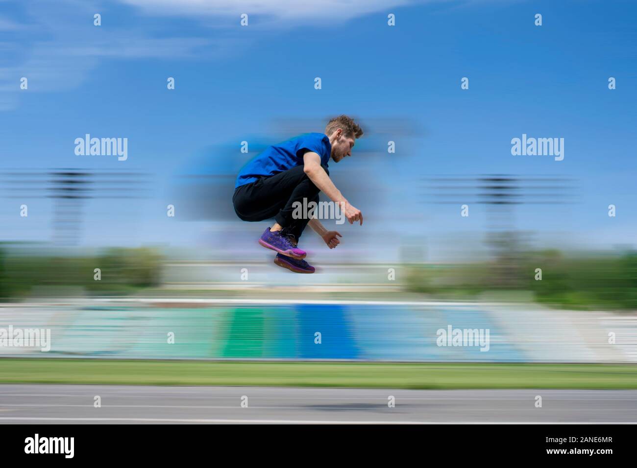 young man athlete practice high jump fly in the air at the stadium on a ...