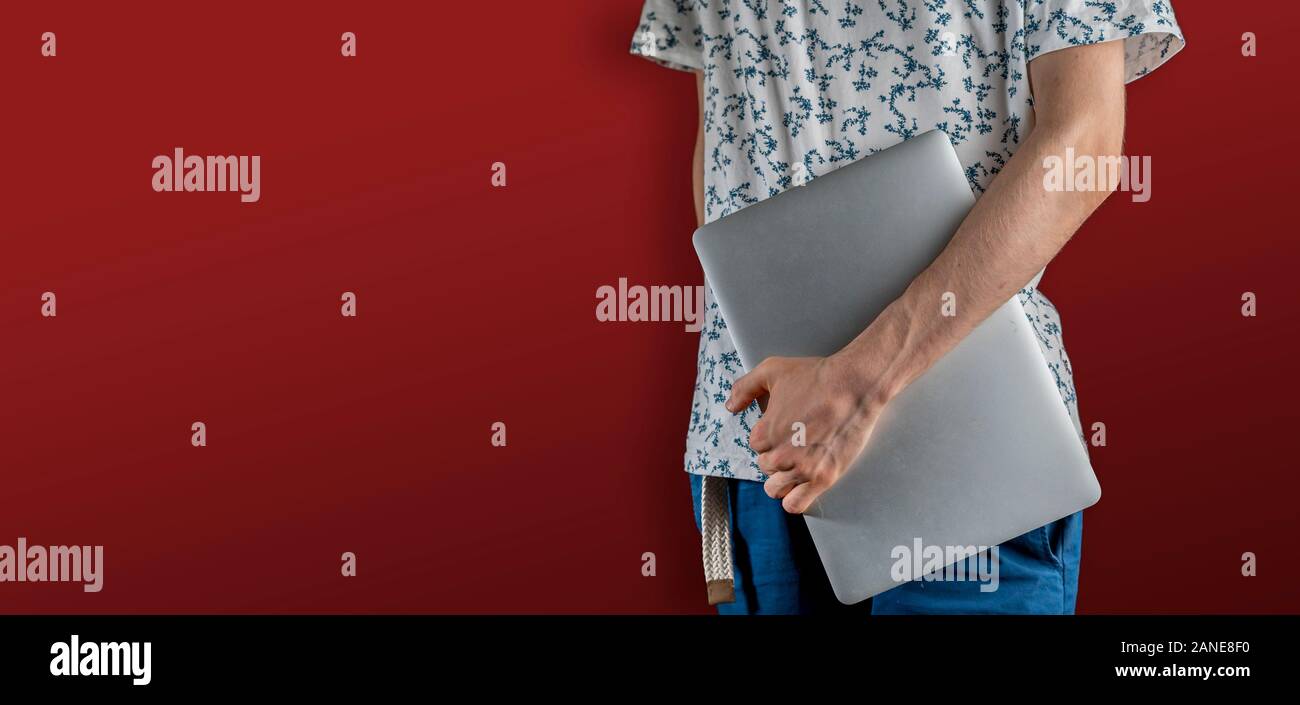 a man holding and carrying the laptop, hug the cumputer standing ...