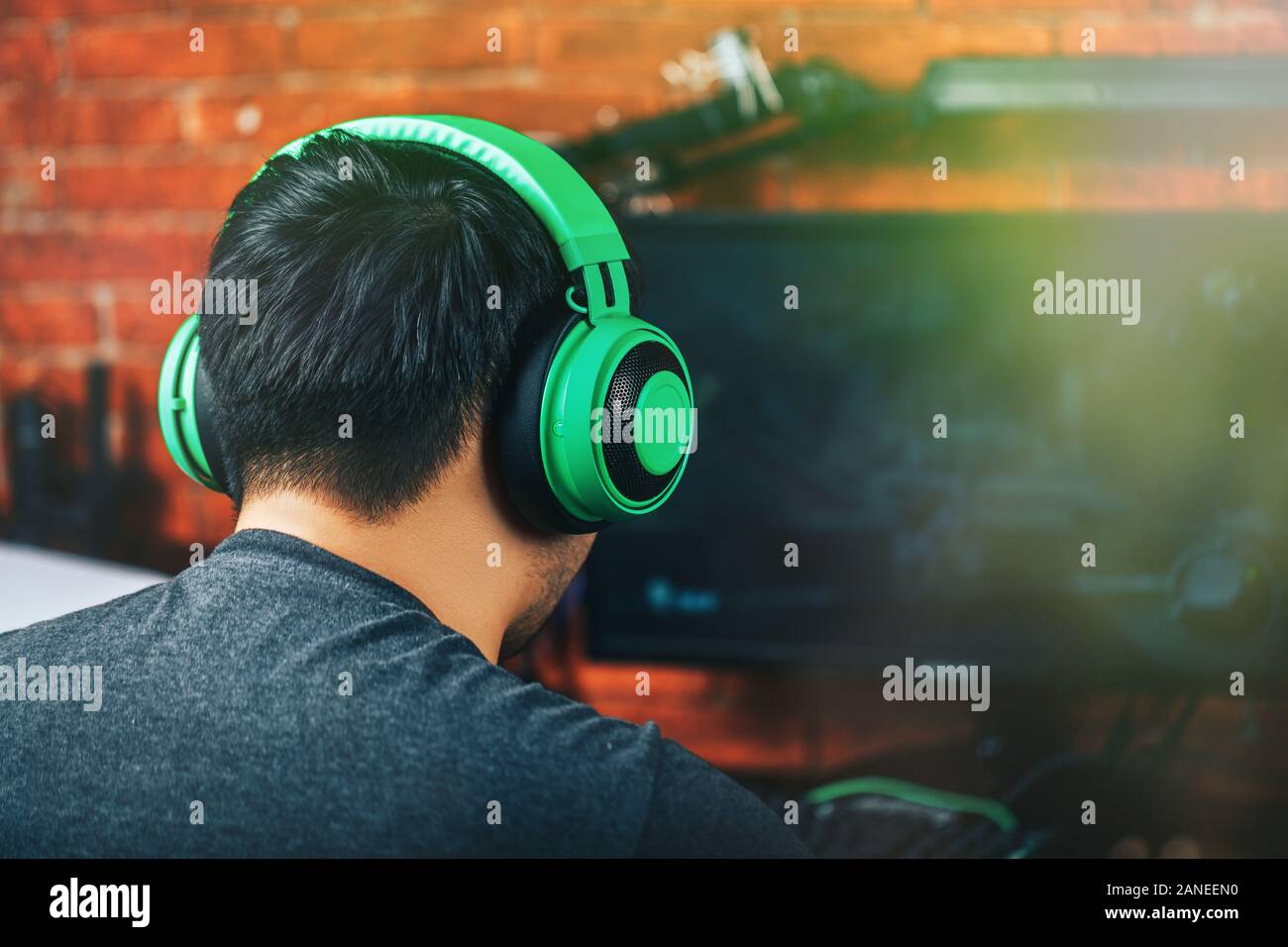 Back view of gamer in headphones playing video game Stock Photo - Alamy