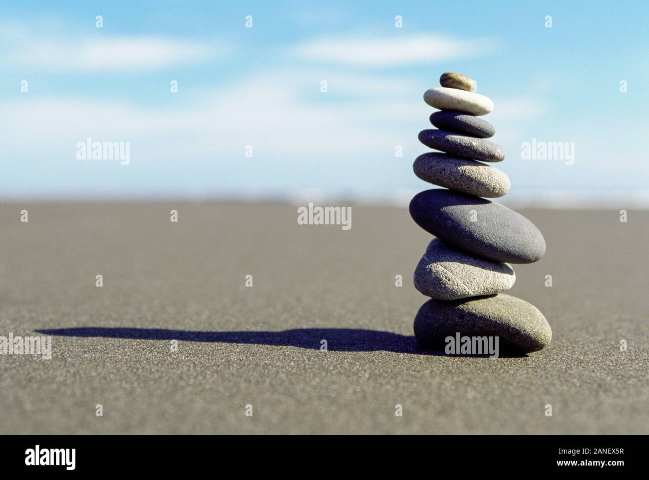A stack of rocks balanced one on top of the other on a sandy beach ...
