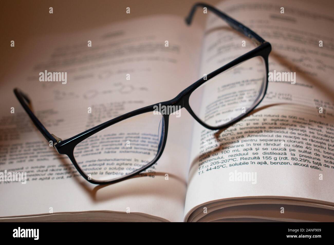 Pair of reading glasses on an opened book, with beautiful shadows ...