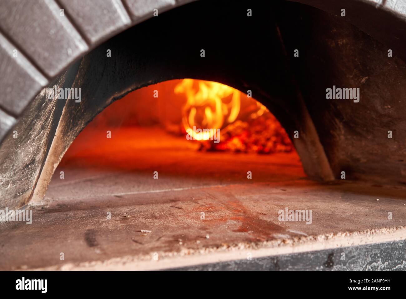 Firewood is burning, the stove is being heated. Red hot coal. Traditional wood oven in Naples ...