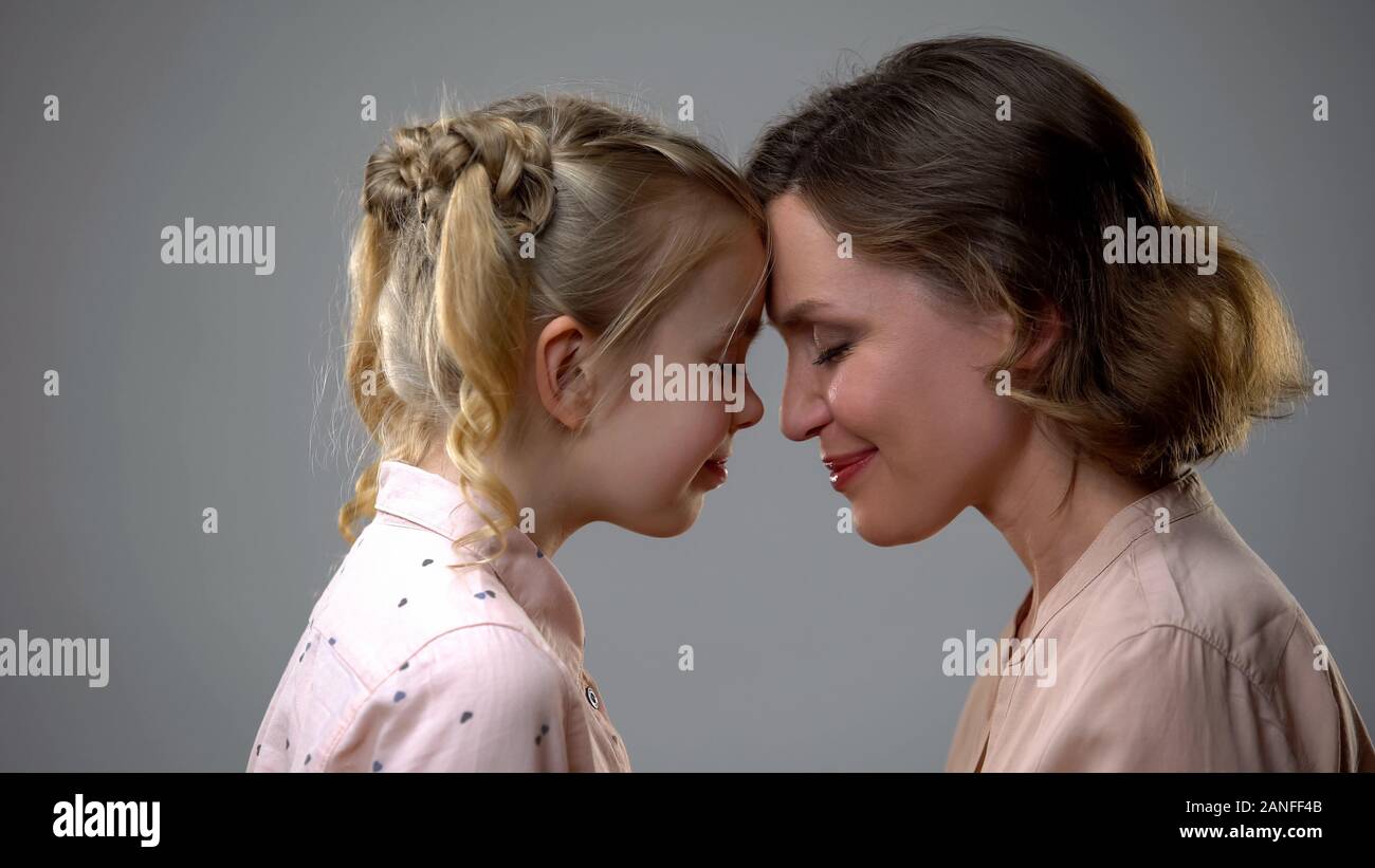 Cute girl and mother touching foreheads, female friendship, family ...