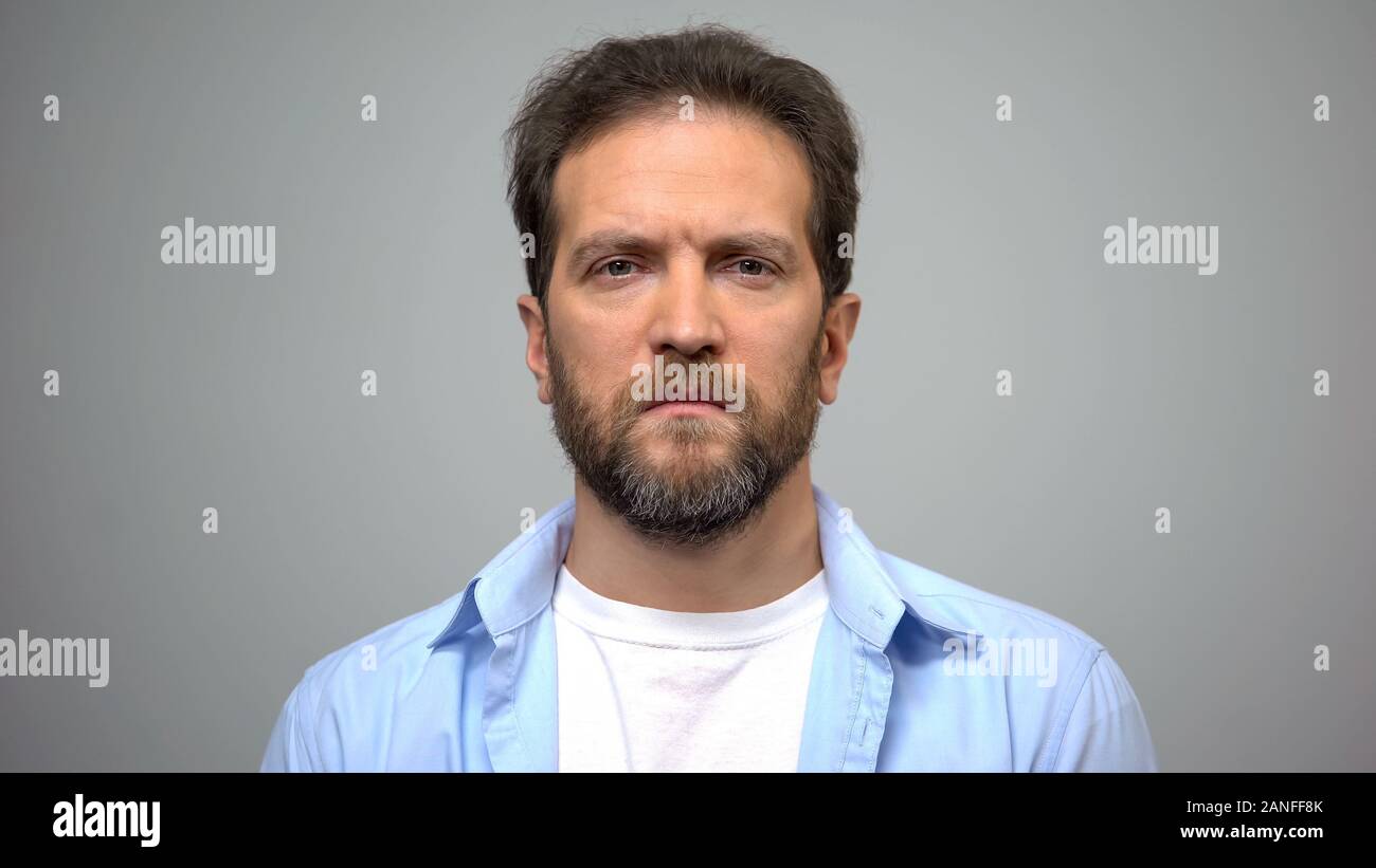 Sad young man on grey background, male loneliness, suffering breakup ...