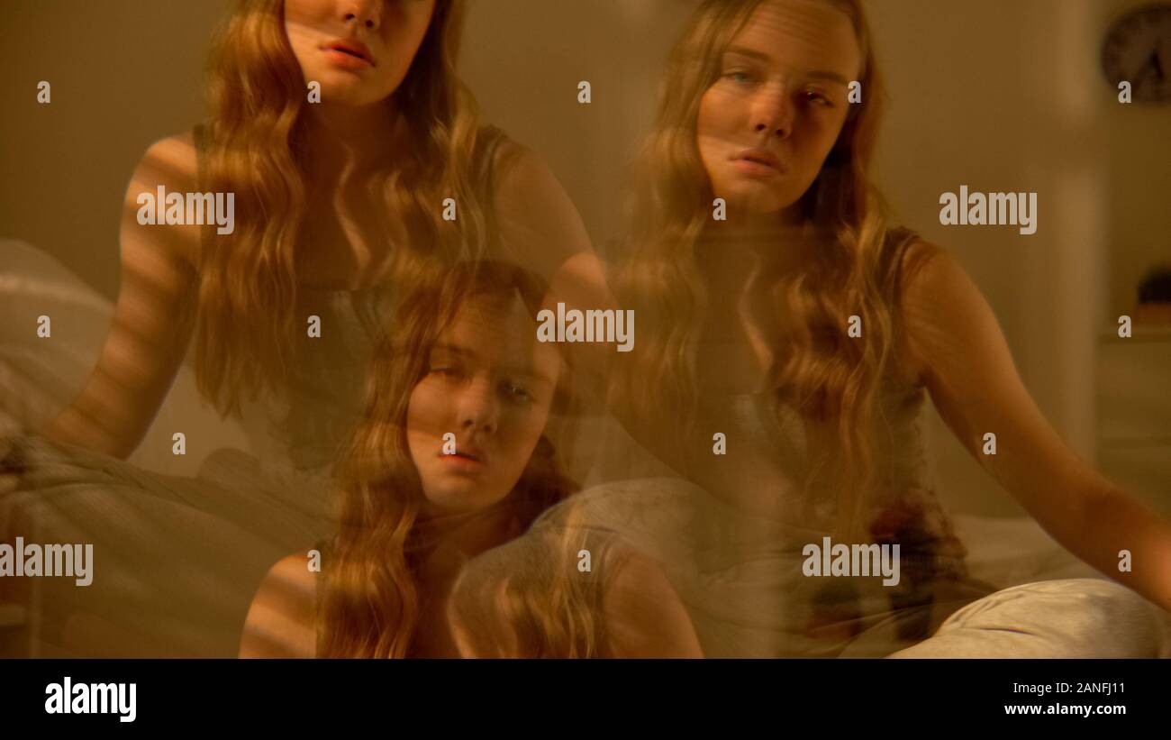 Teen drug intoxicated female sitting on bed and hallucinating ...