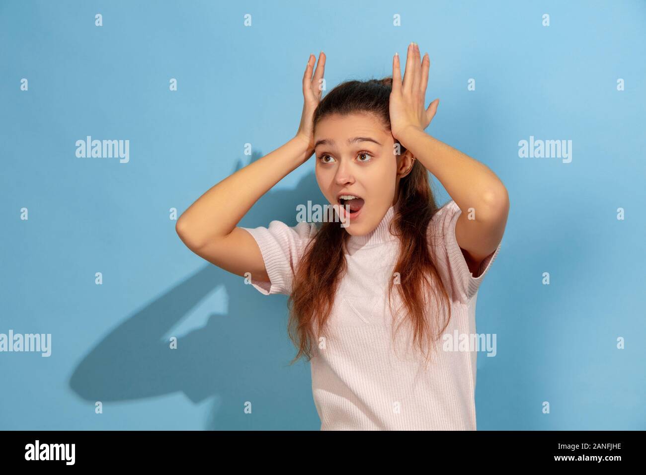 Laughting, shocked, calling. Caucasian teen girl's portrait on blue ...