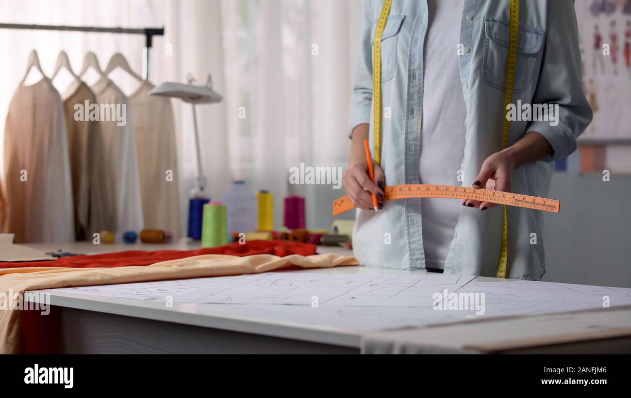 Fashion designer measuring fabric according hi-res stock photography ...