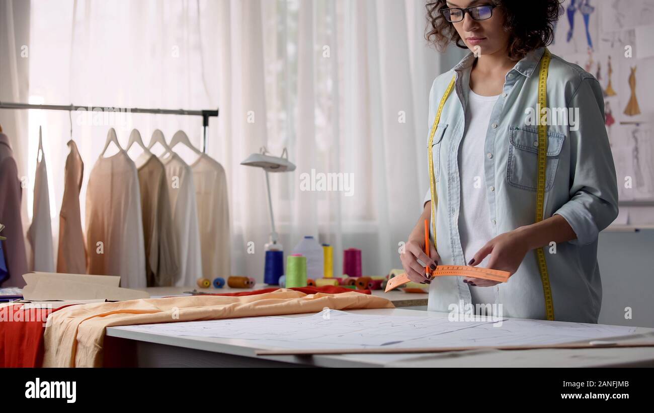 Professional seamstress marking patterns, considering dimensions of ...