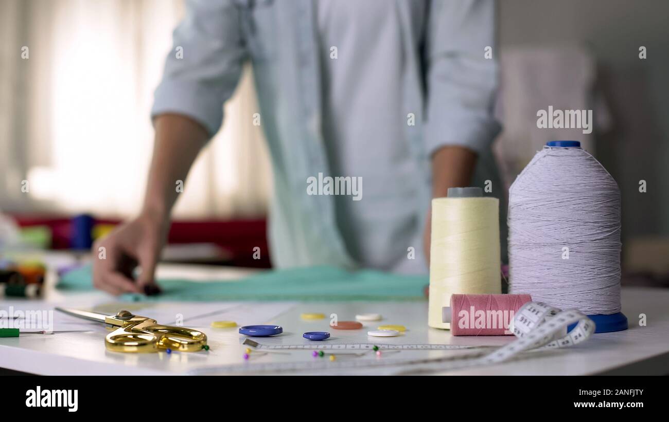 Girl designer measuring size of fabric, workflow in workshop ...