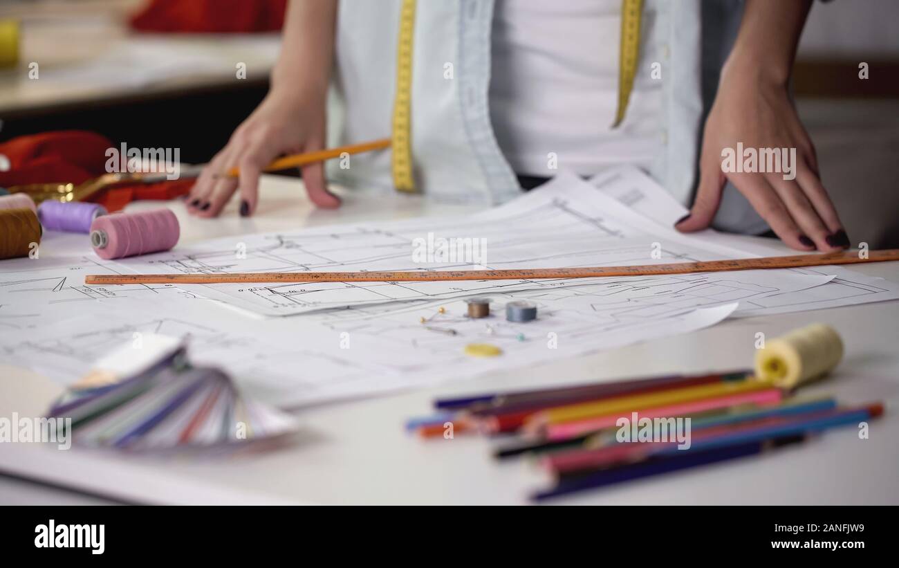 Female stylist working on creation of new sketches and patterns in her ...