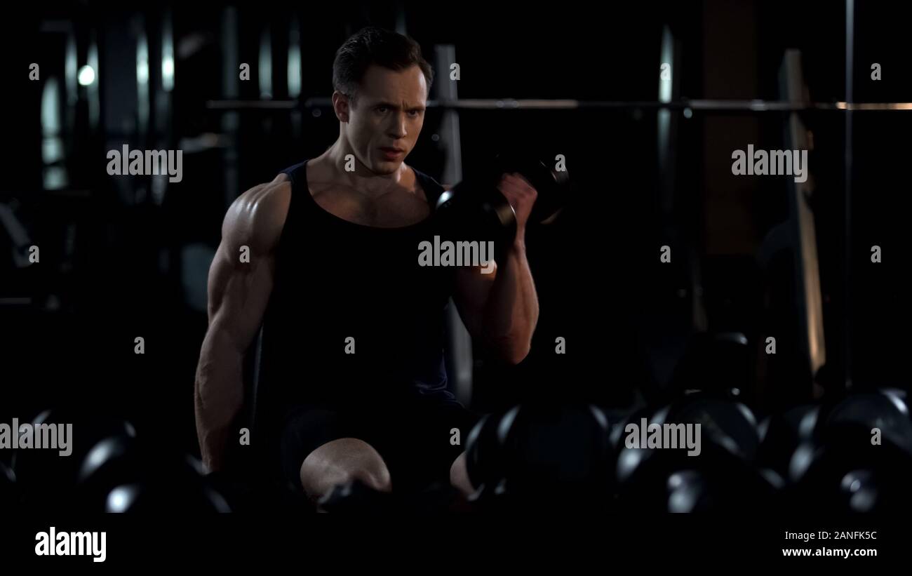 Handsome bodybuilder doing seated alternated hi-res stock photography ...