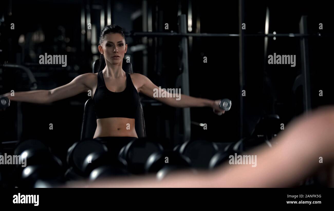 Beautiful lady doing tough workout in gym after office work, mirror ...