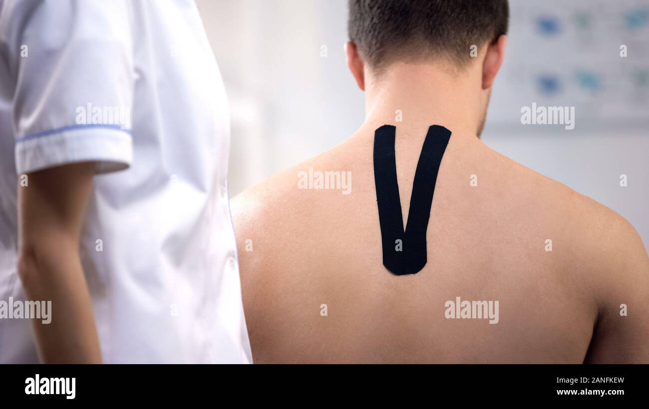 Patient with Y-shaped tape on upper back, doctors visit, alternative ...