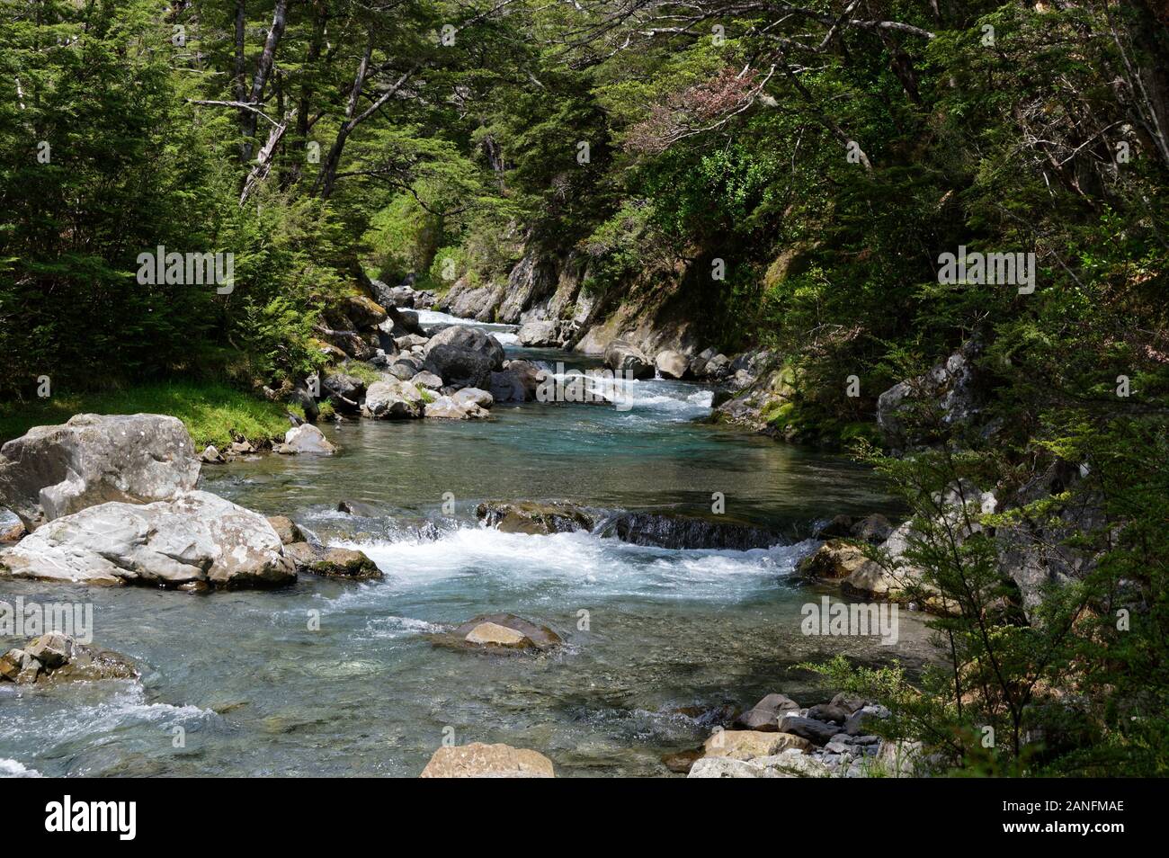 A river's water changes from blue to white as it cascades over rocks ...