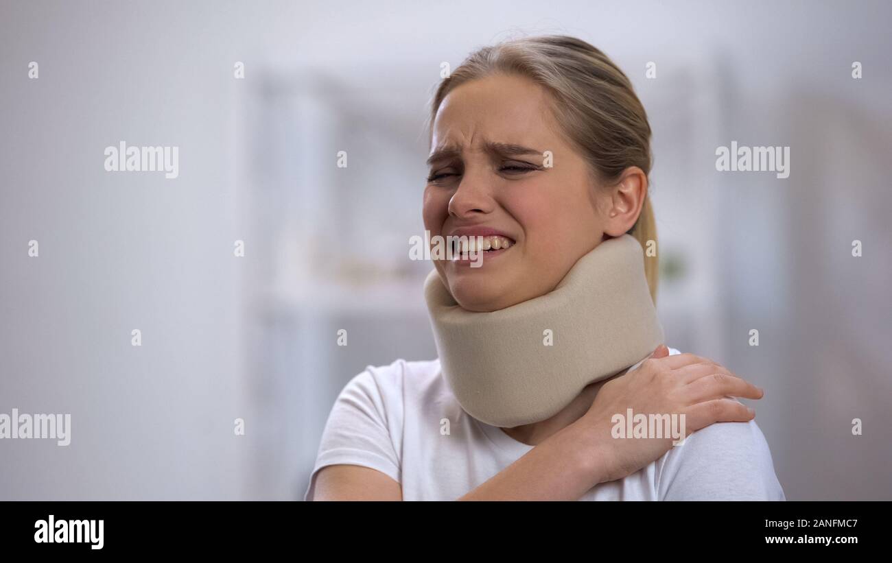 Upset girl in foam cervical collar suffering pain in shoulder, accident ...