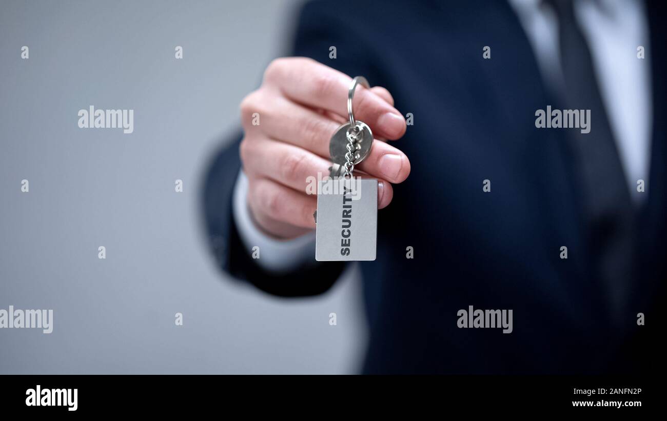 Security word on keychain in businessman hand, home safety system ...