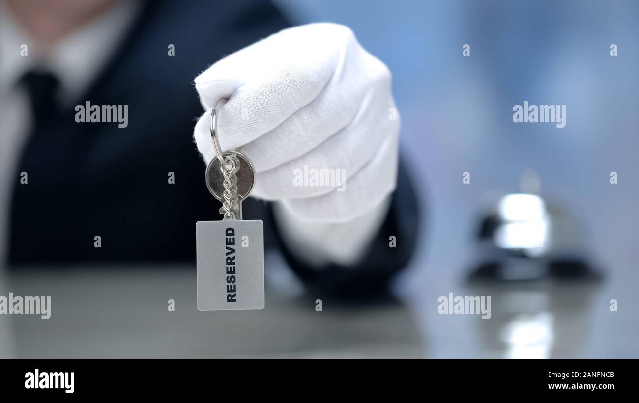 Administrator holding keys to Reserved room, luxury hotel, hospitality ...