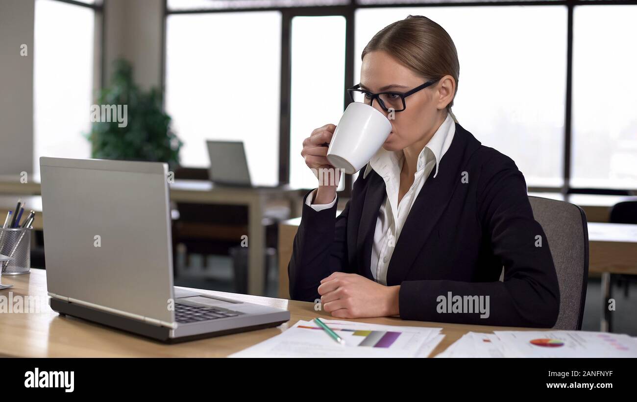 Businesswoman drinking coffee in office, having break, resting after ...