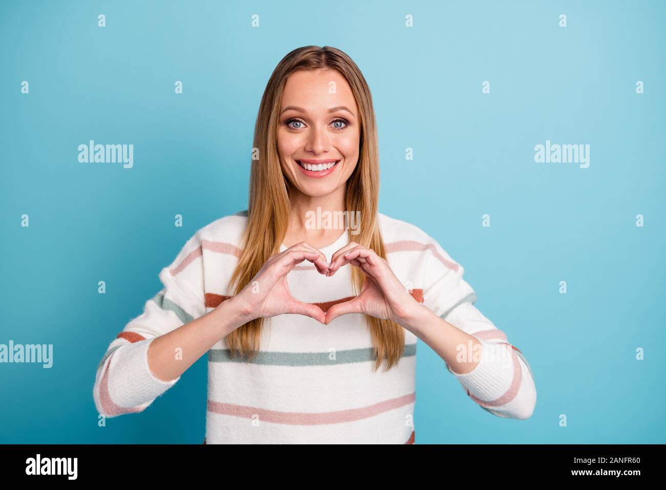 Photo of cheerful toothy beaming sweet woman showing heart shape sign ...