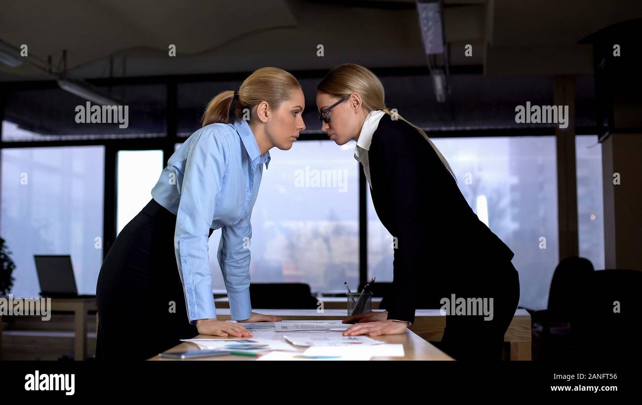 Two businesswomen looking with challenge at each other, competition at ...