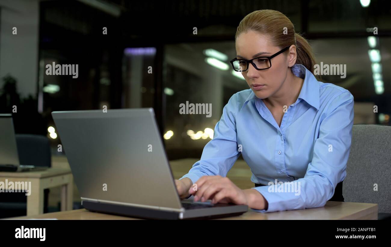 Sleepy employee working late at night on laptop, hurrying to finish ...