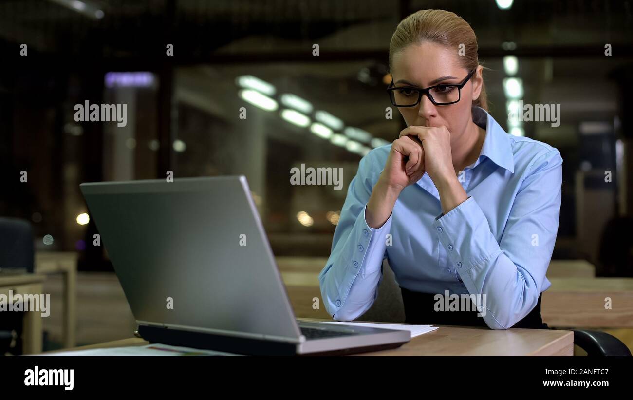 Nervous business woman looking at laptop, afraid of work failure and ...