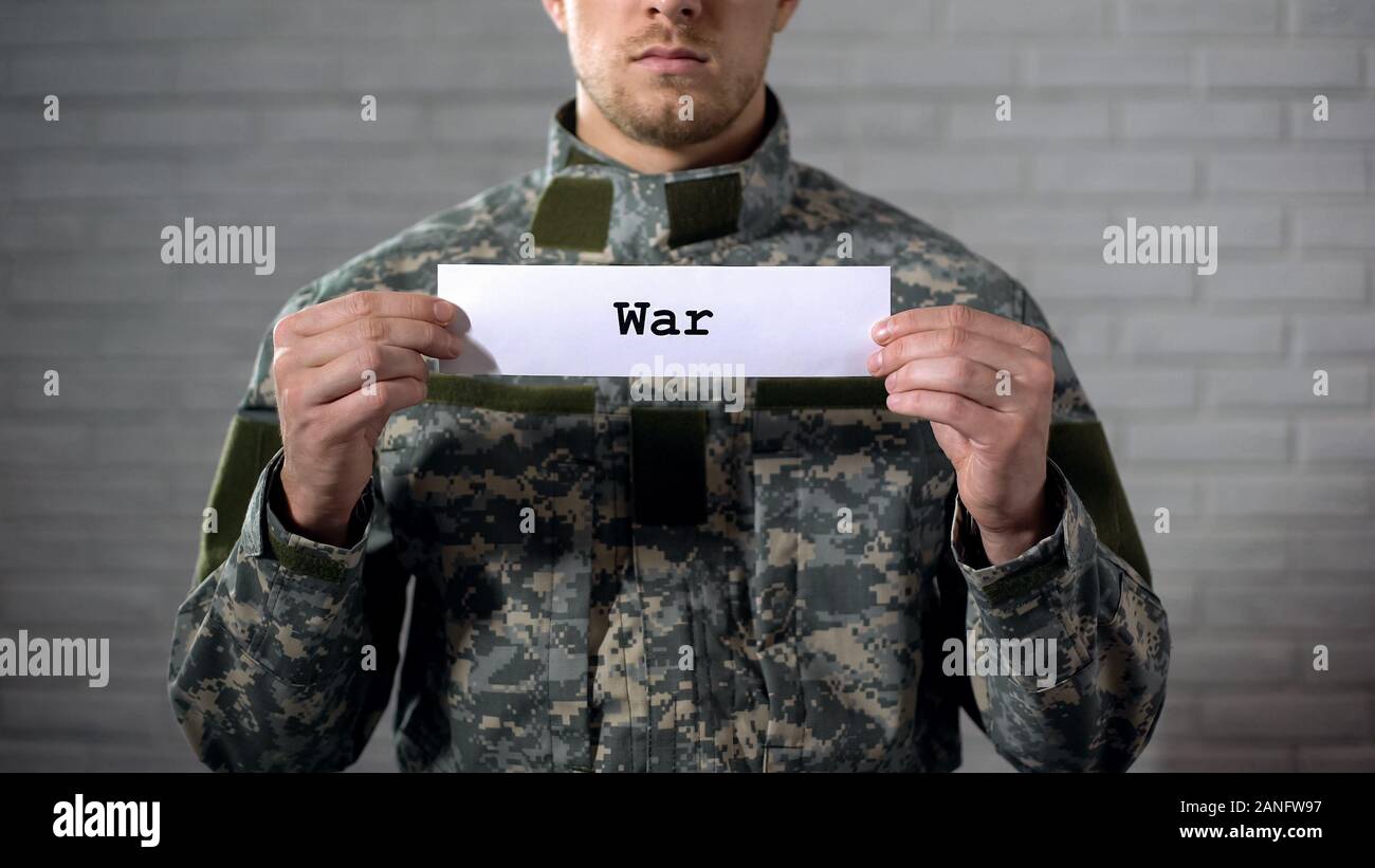 War word written on sign in hands of male soldier, armed conflict ...