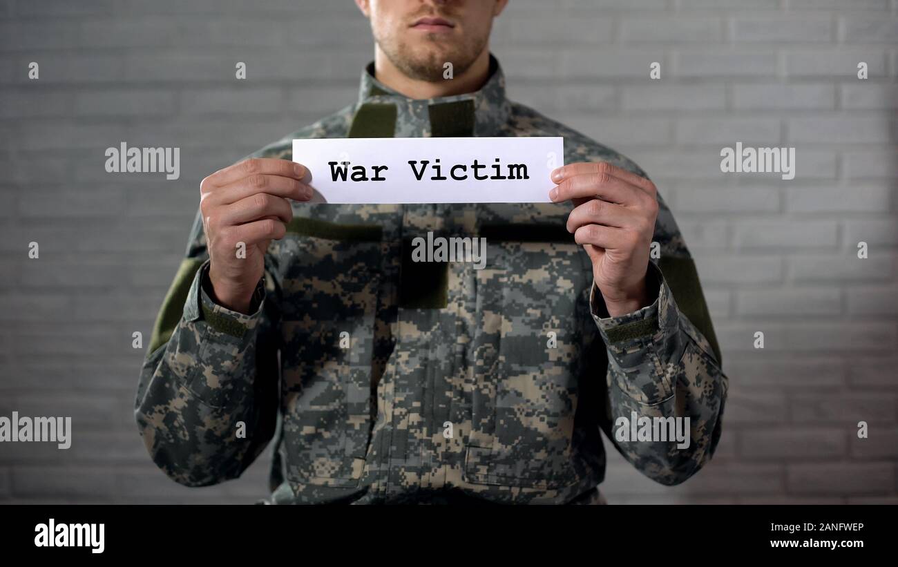 War victim word written on sign in male soldier hands, mental disorder ...