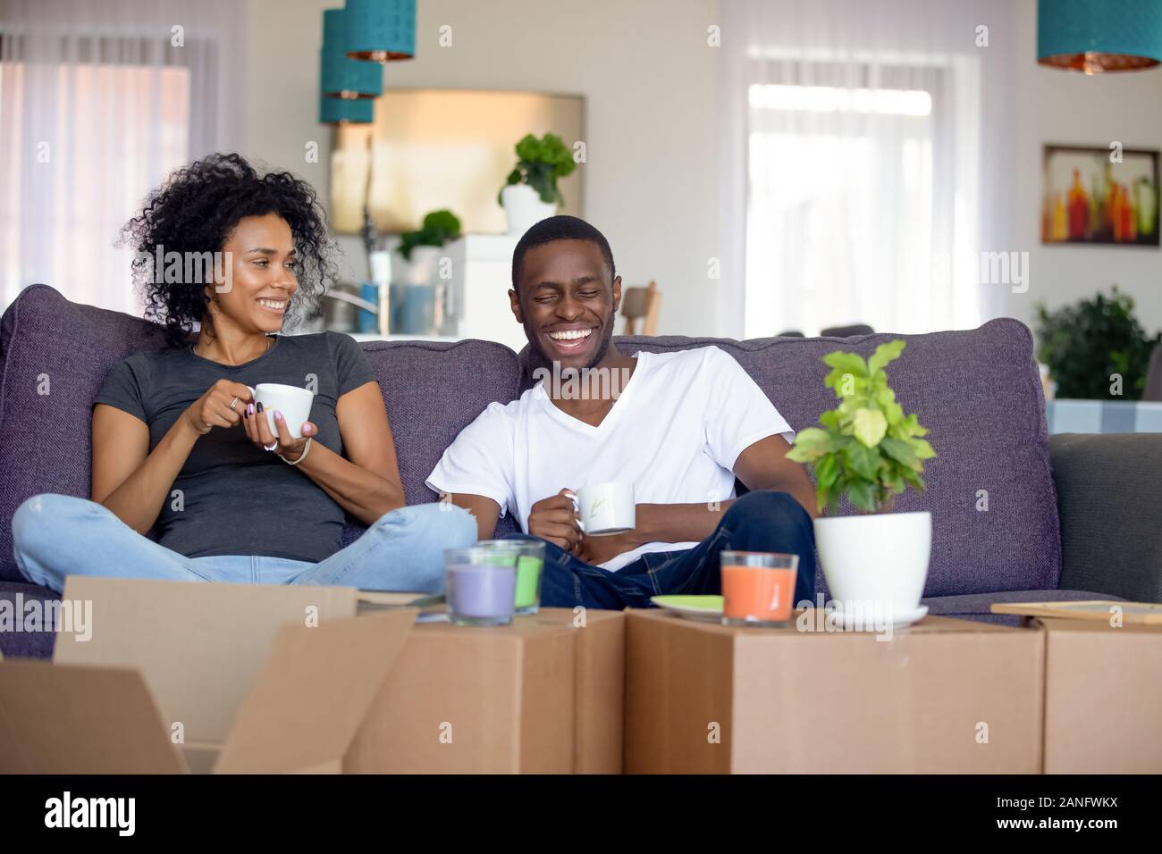 Happy black couple enjoy tea making break in unpacking Stock Photo - Alamy