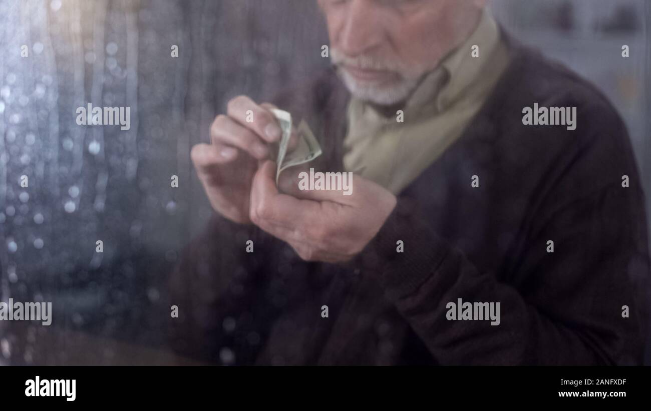 Poor retired man counting money in hand, economic crisis, financial ...