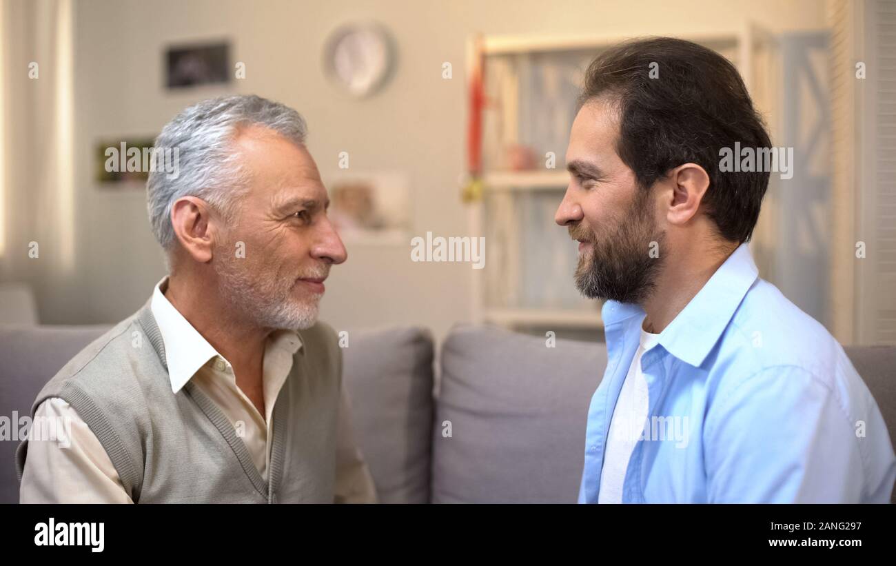 Father and son looking at each other with love and respect, family ...