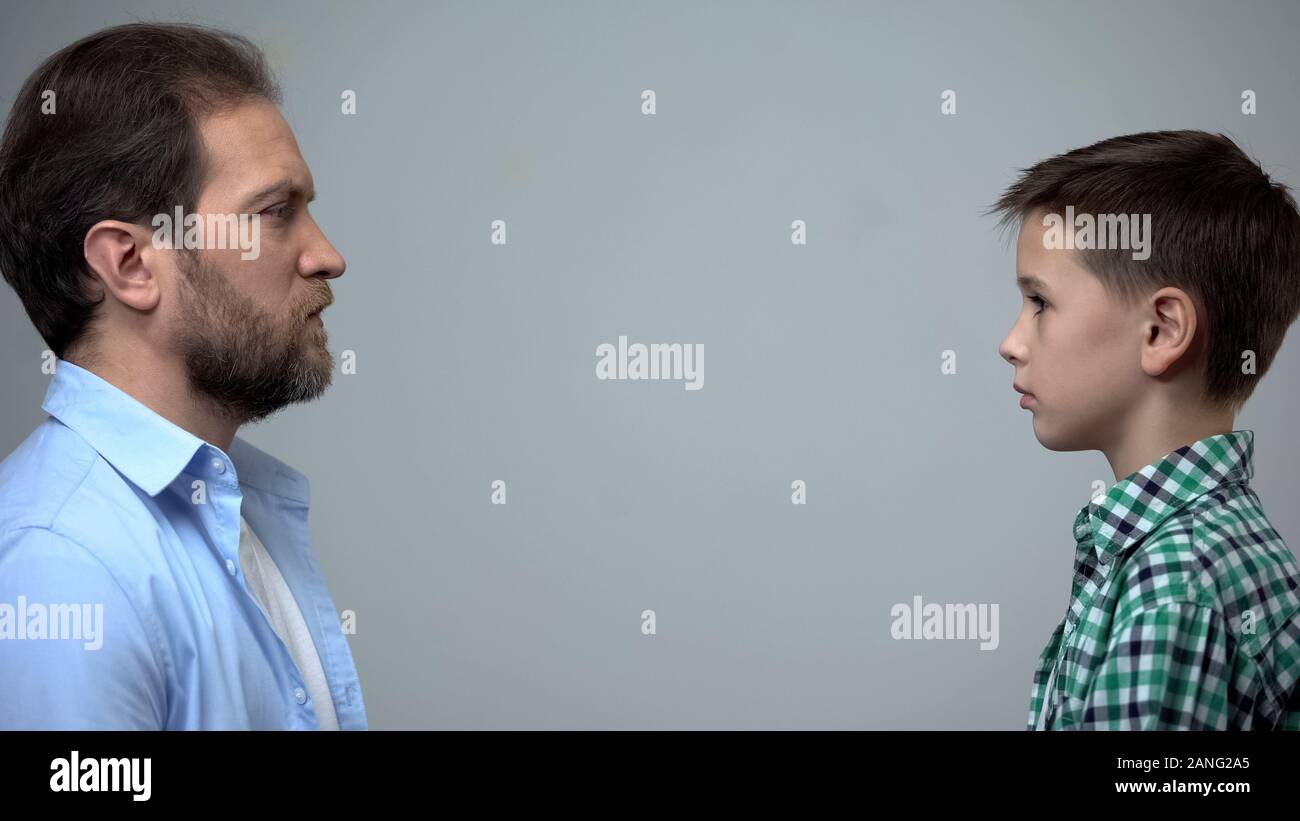 Serious father looking at little son, child upbringing, adoption and ...