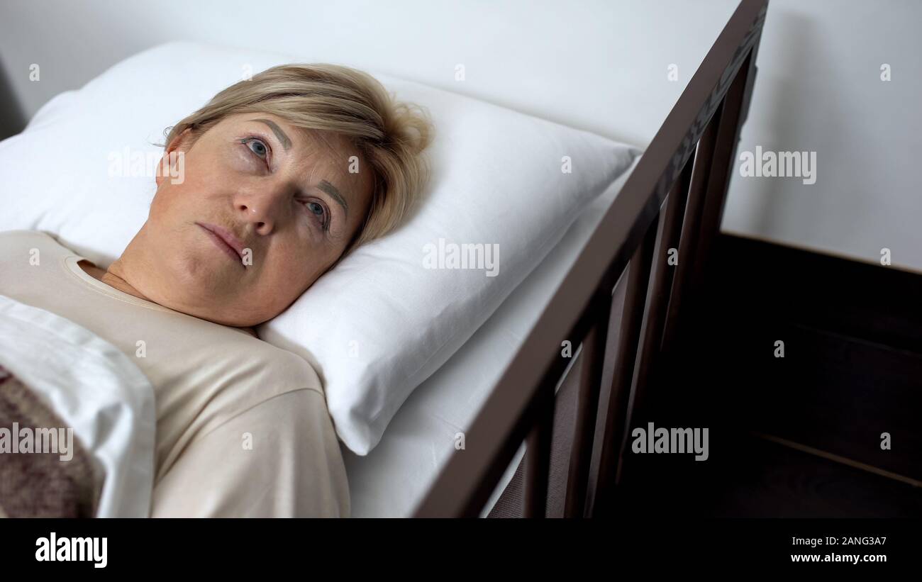 Female patient lying in hospital bed and looking around, amnesia health ...