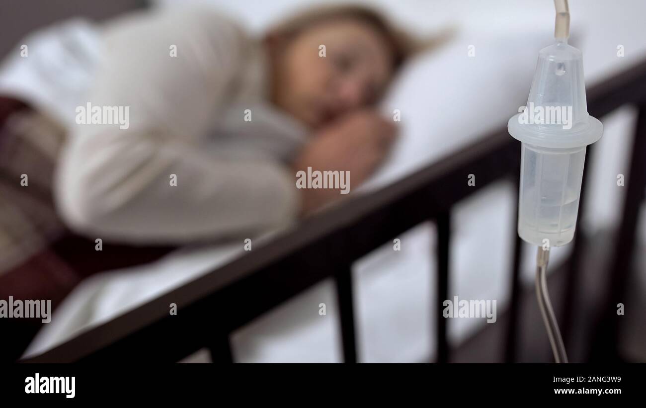 Dropper close-up, sick woman sleeping in hospital bed on background ...