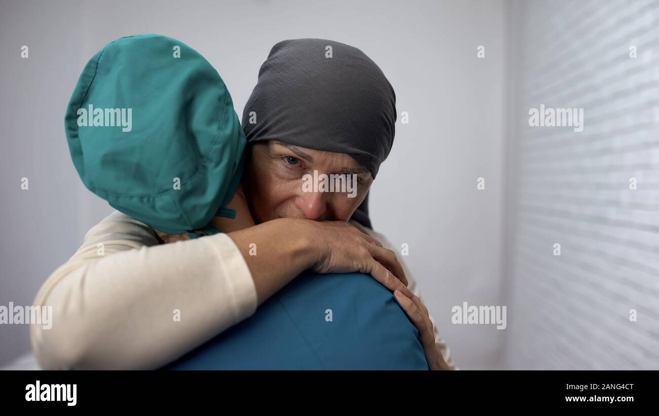 Depressed woman crying and hugging oncologist expensive treatment ...