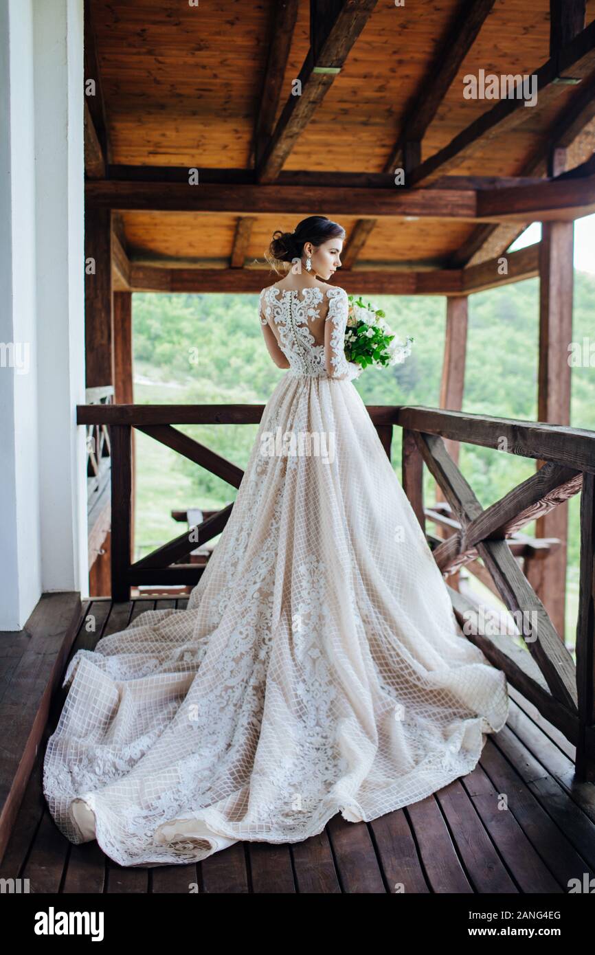 The bride in a magnificent, white, wedding dress with a long train ...