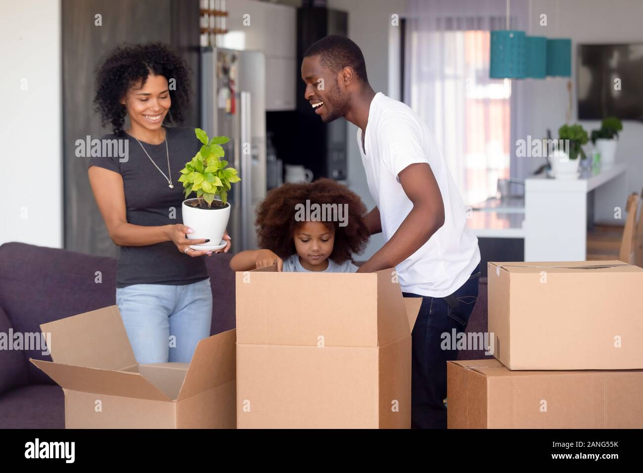 Happy African American family unpacking boxes after relocating Stock ...