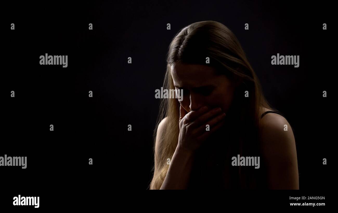Crying lady sitting alone against dark background, suffering from life ...