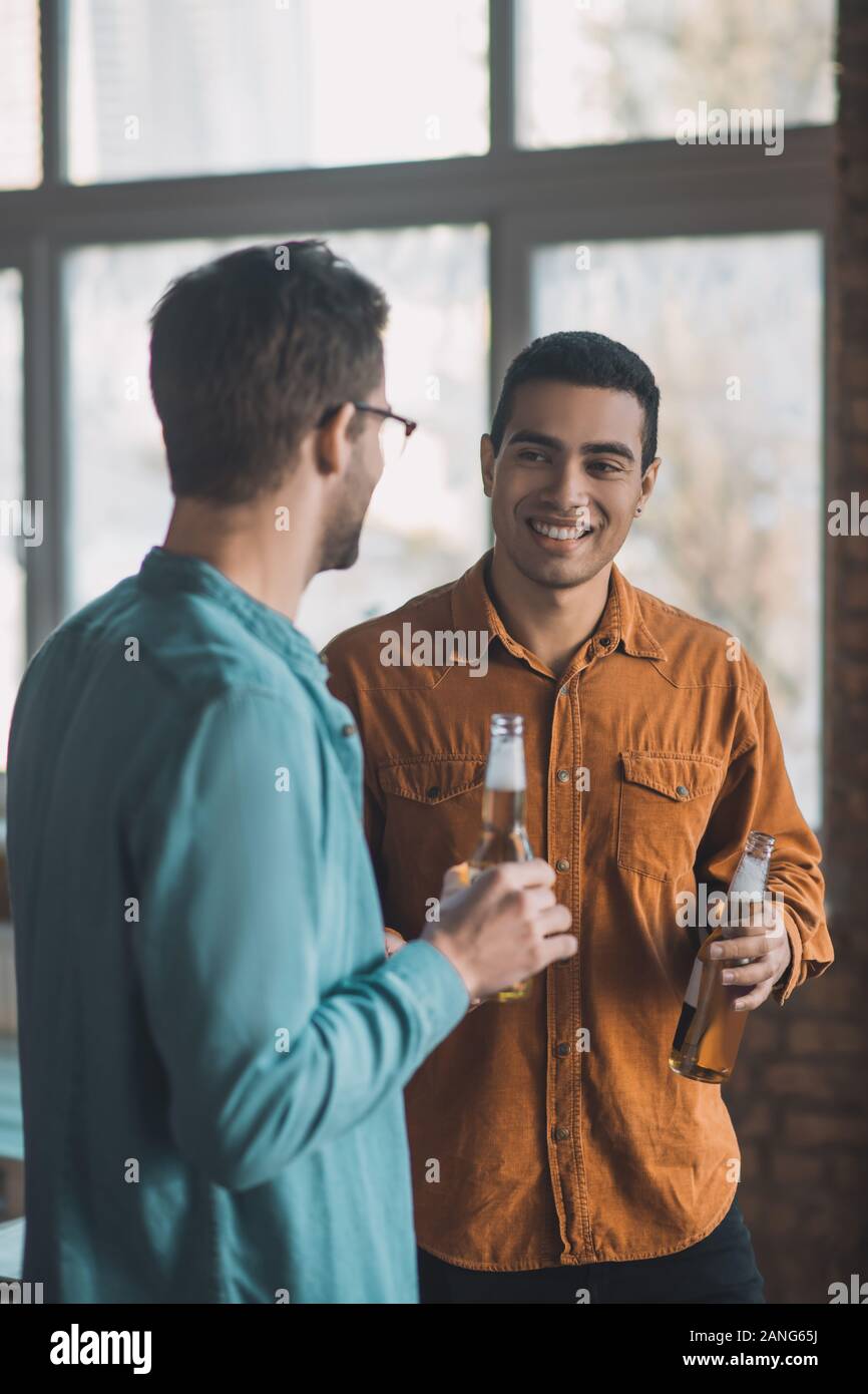 Positive young men having a pleasant conversation Stock Photo - Alamy