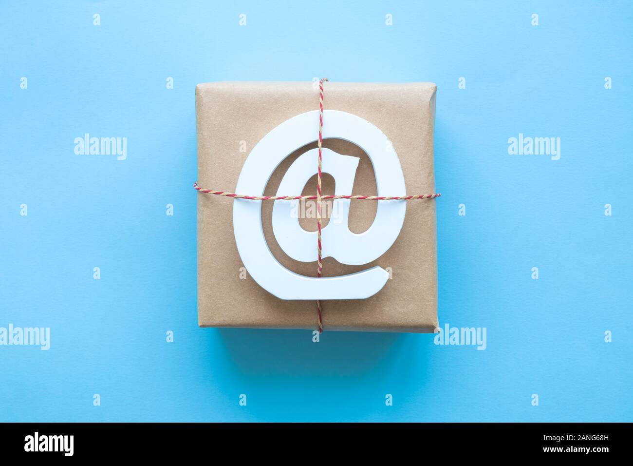 Flat lay of wrapped package with email symbol isolated on pastel blue ...