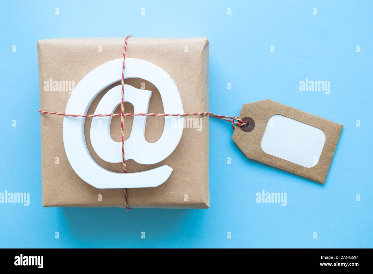 Flat lay of wrapped package with email symbol and blank tag isolated on ...
