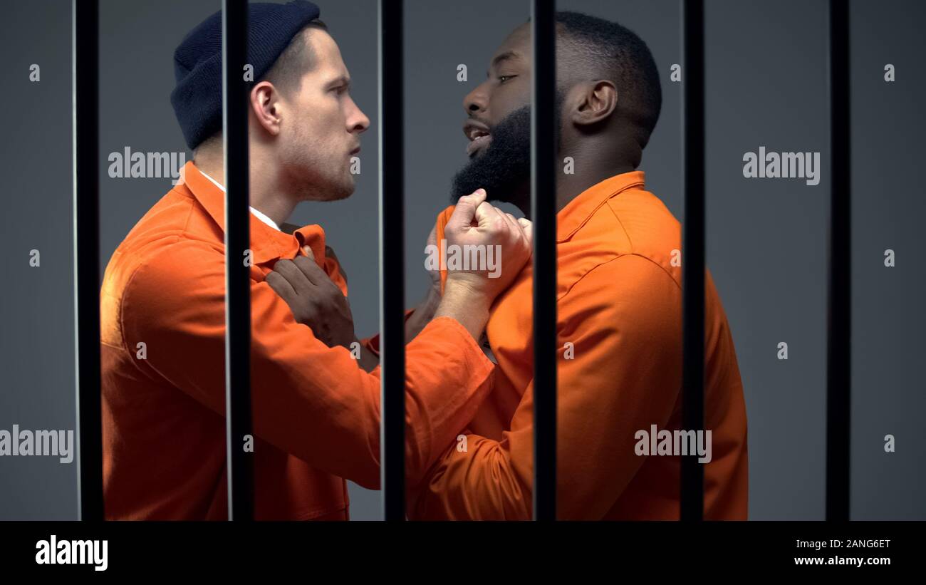 Black and caucasian prisoners having fight in cell, jail overcrowding ...