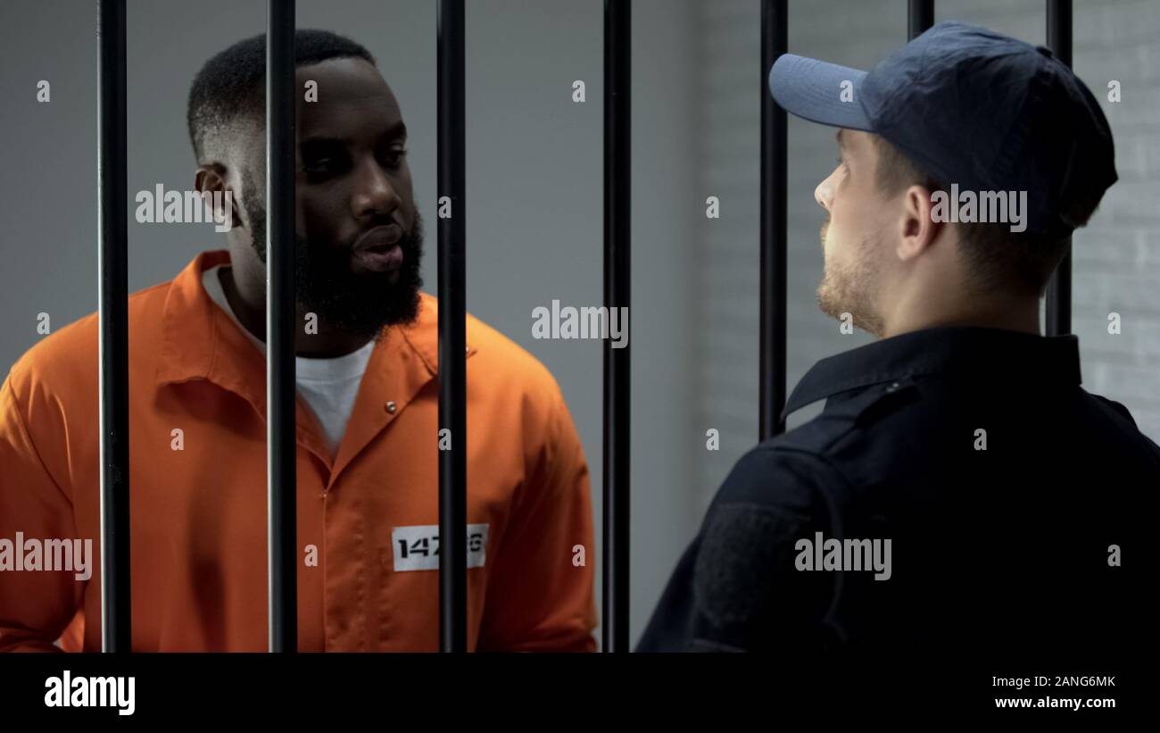 Afro-american prisoner making arrangement with prison guard, corruption ...
