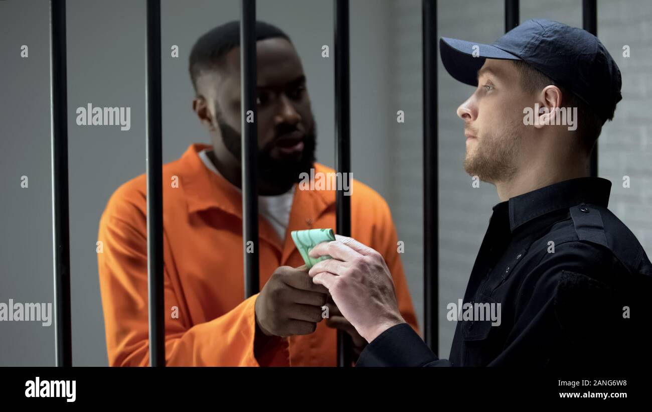 Prison guard taking euro banknotes from afro-american criminal ...