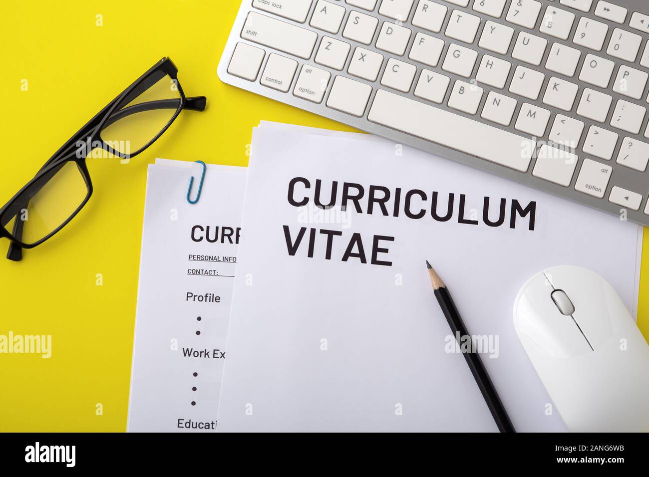 CV, curriculum vitae with computer keyboard, pencil on yellow table ...