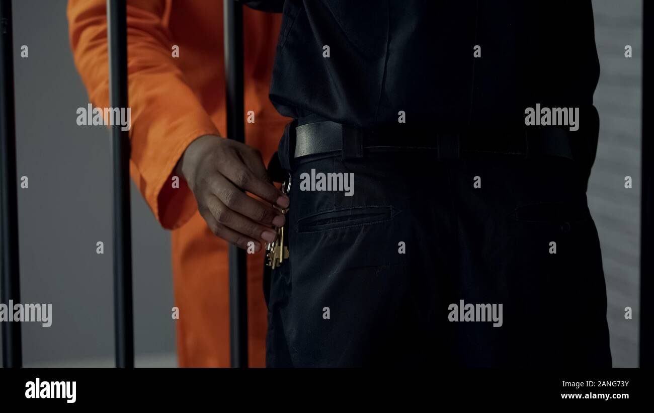 Afro-american prisoner stealing keys from security guard, preparing ...