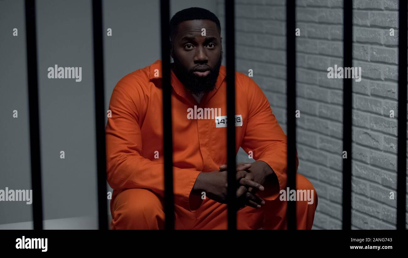 Frightened black prisoner sitting in cell, human rights protection ...